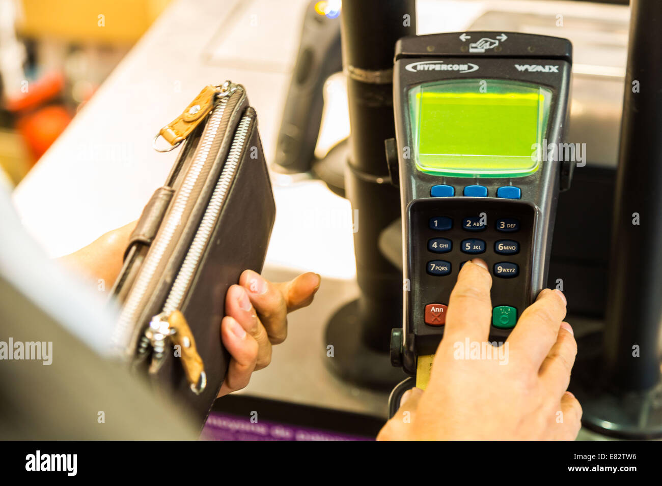 Woman paying at the checkout counter of supermarket Stock Photo - Alamy