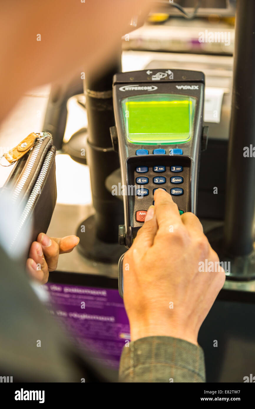 Woman paying at the checkout counter of supermarket Stock Photo - Alamy