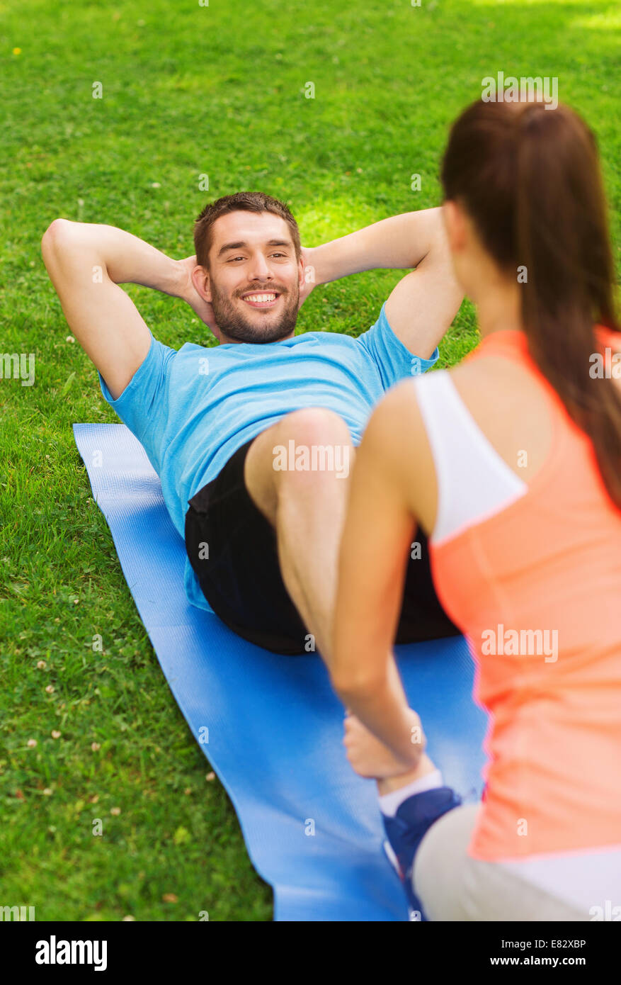 smiling man doing exercises on mat outdoors Stock Photo - Alamy