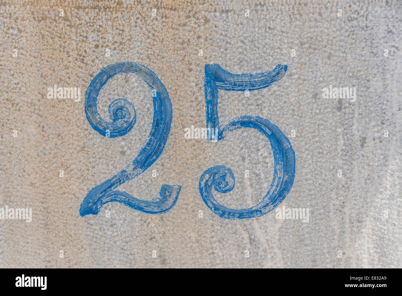 Number 25 painted on stone in an ornate blue font Stock Photo - Alamy