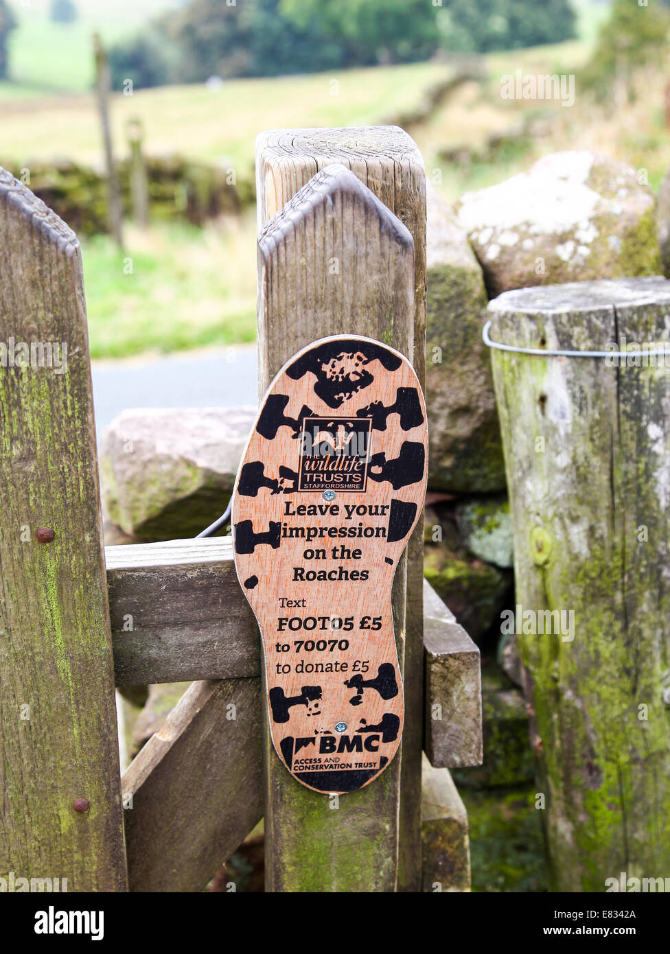 A sign in the shape of a footprint on a gate appealing for donations to ...