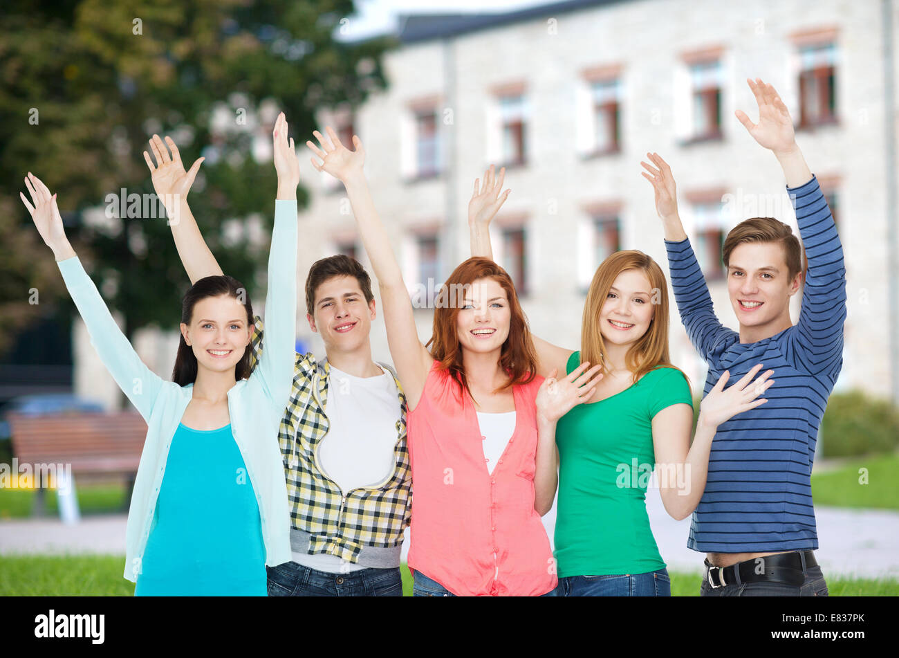 group of smiling students waving hands Stock Photo - Alamy