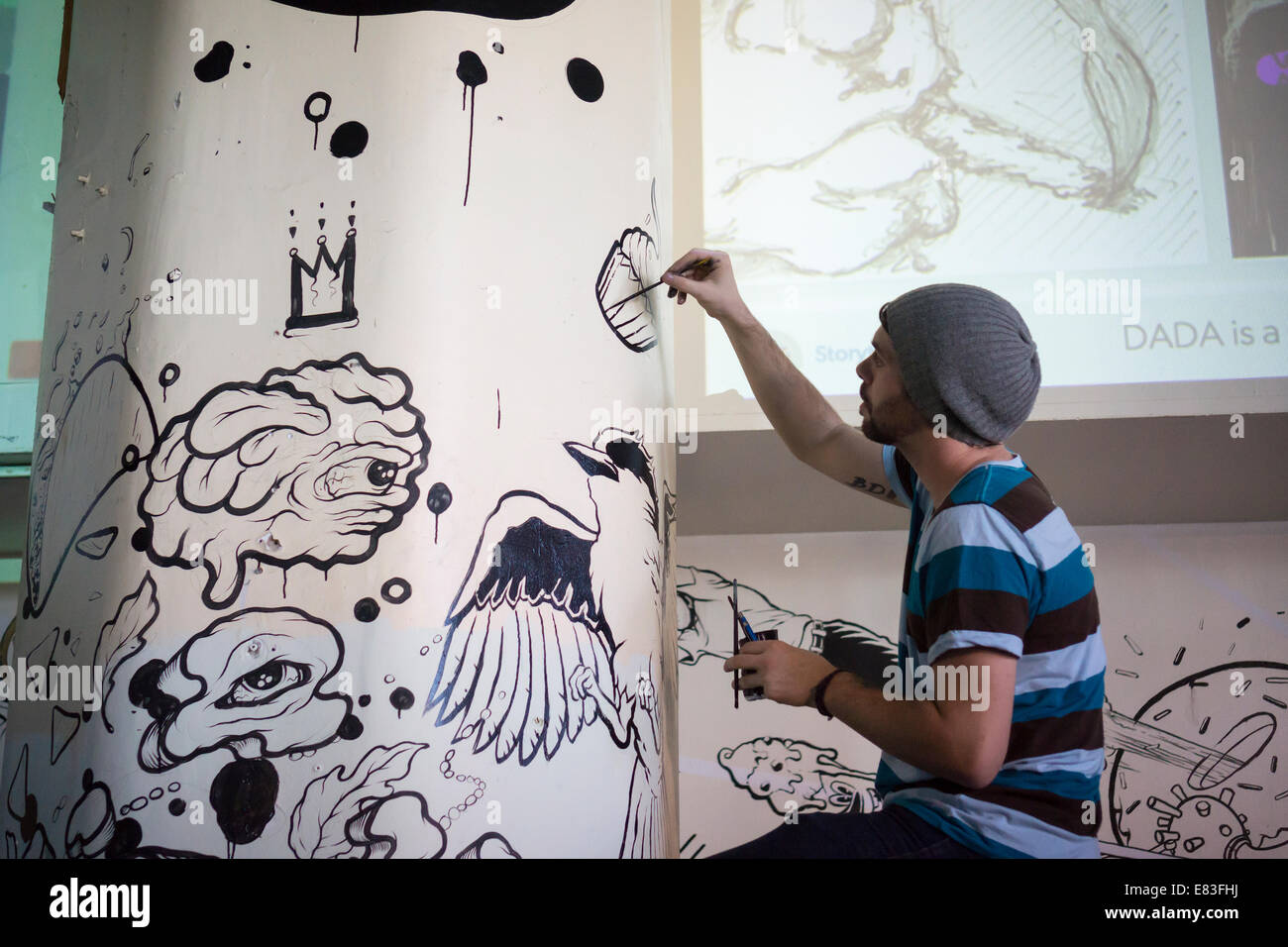An artist from the En Masse Collective paints a mural in the Brooklyn ...