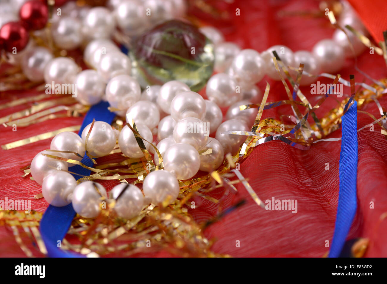 String of pearls on red background Stock Photo - Alamy