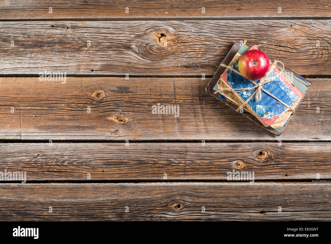 Small pile of books and apple on school desk Stock Photo - Alamy
