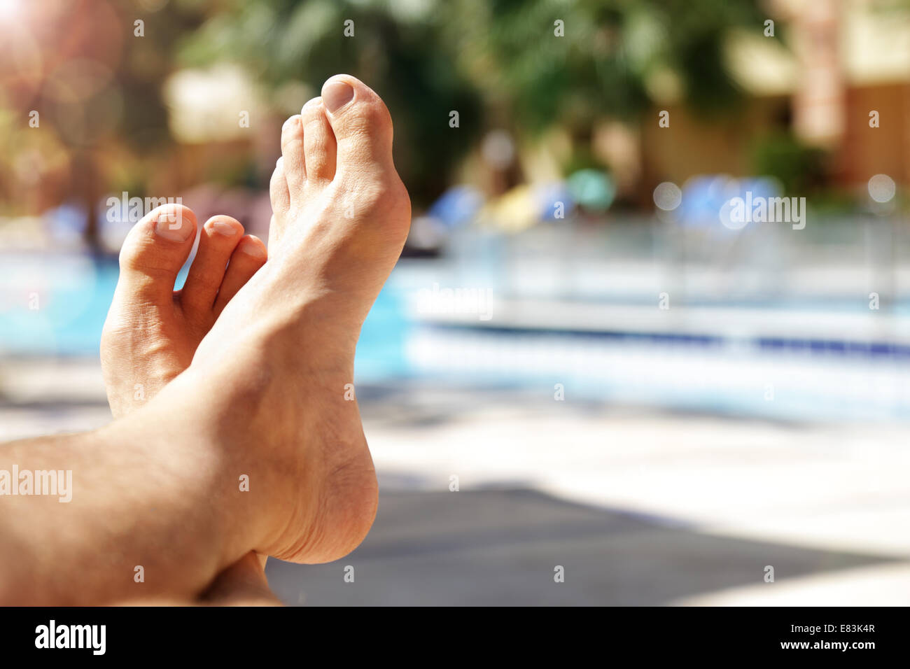 Sunbathing by swimming pool Stock Photo - Alamy