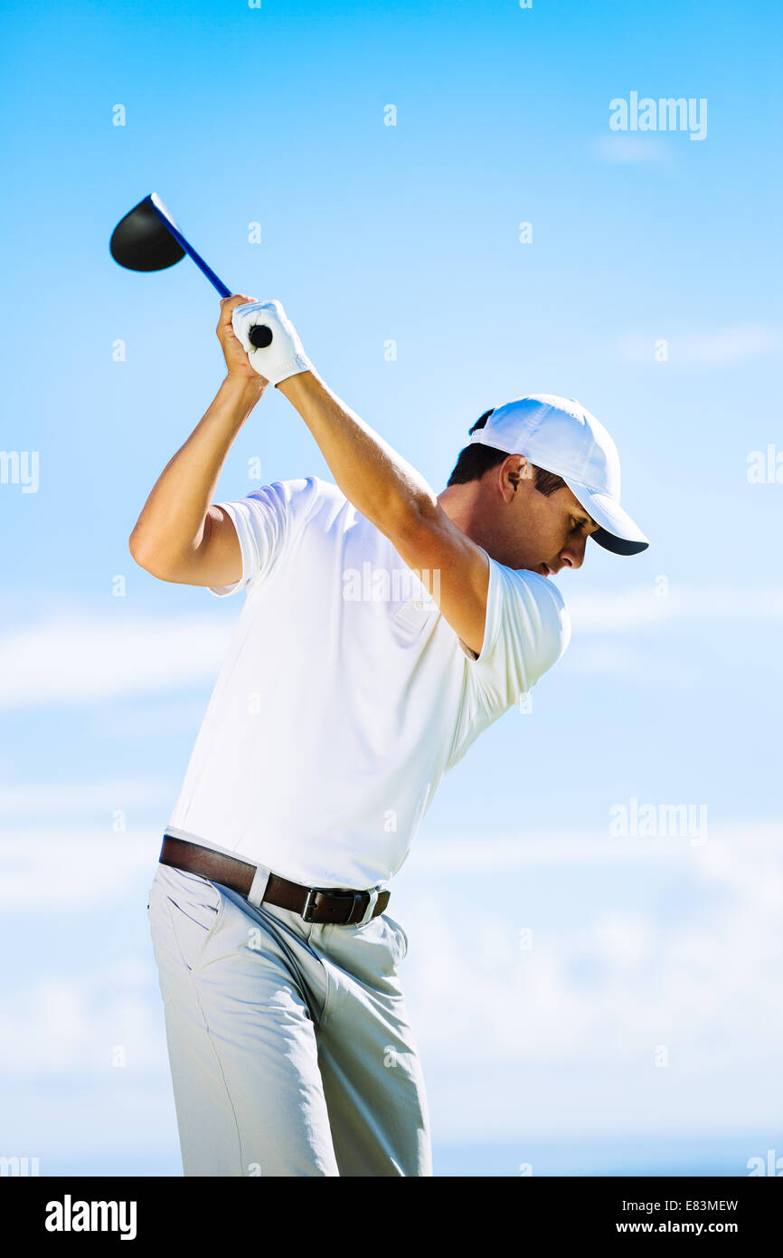 Man Swinging Golf Club with Blue Sky Background Stock Photo - Alamy
