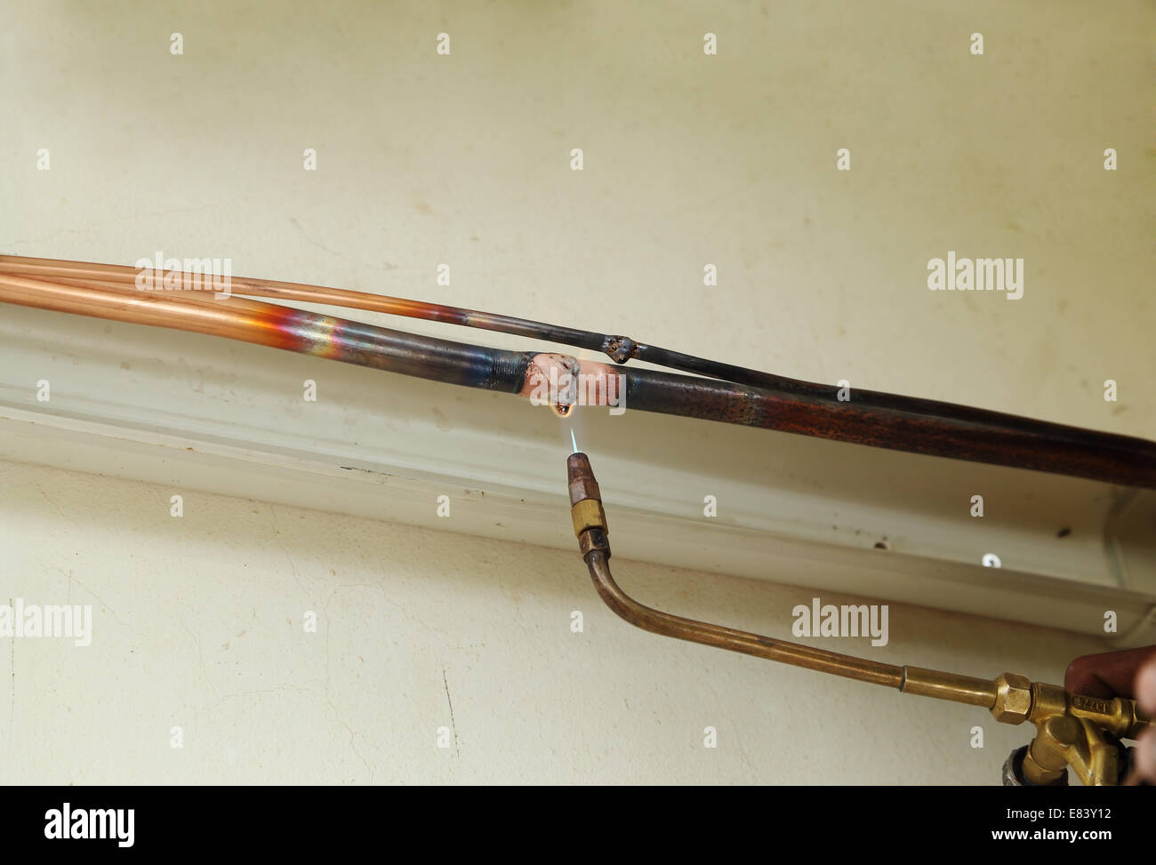 Air conditioner repairman welding copper pipes Stock Photo - Alamy