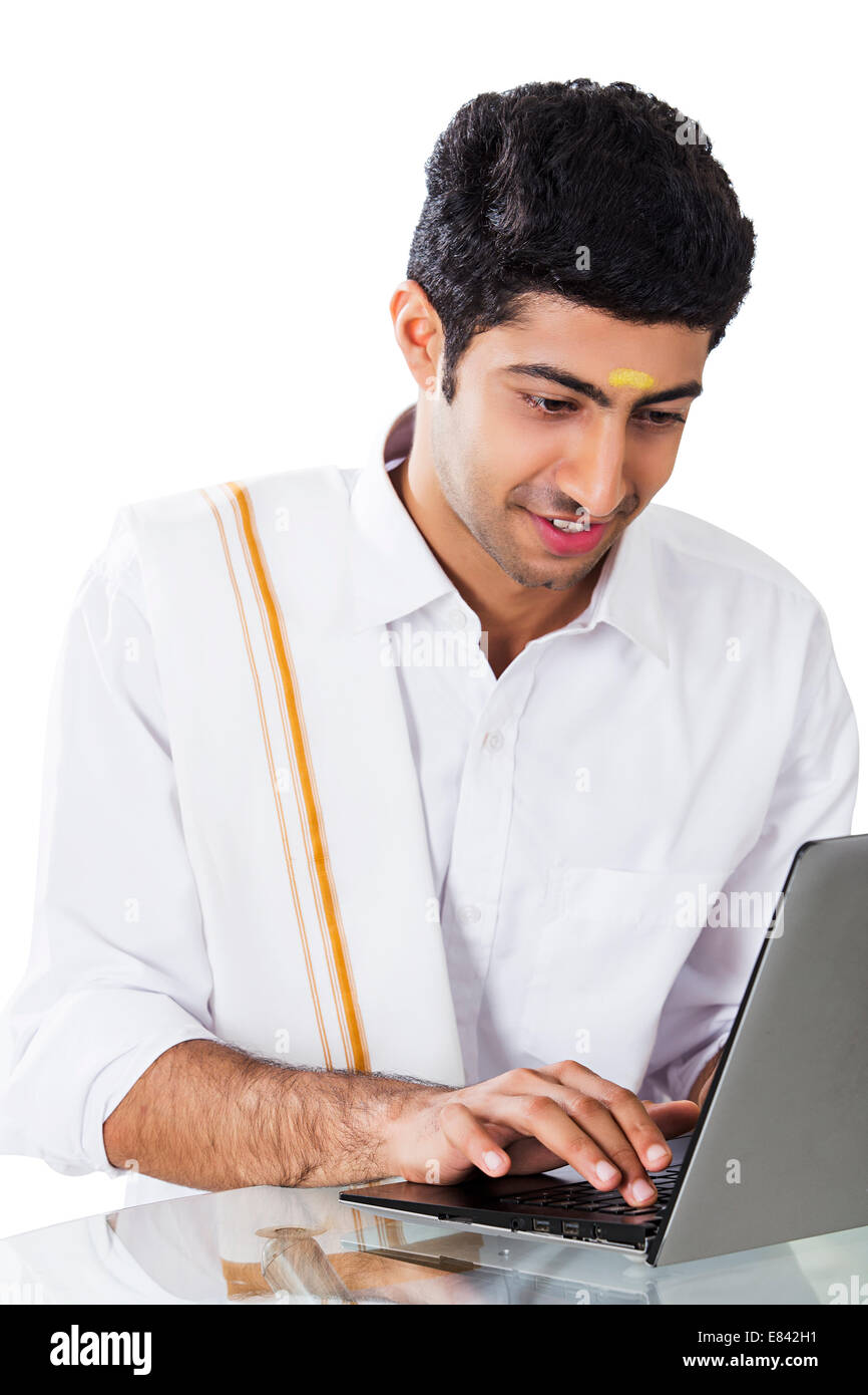 South Indian man working laptop with phone Stock Photo - Alamy