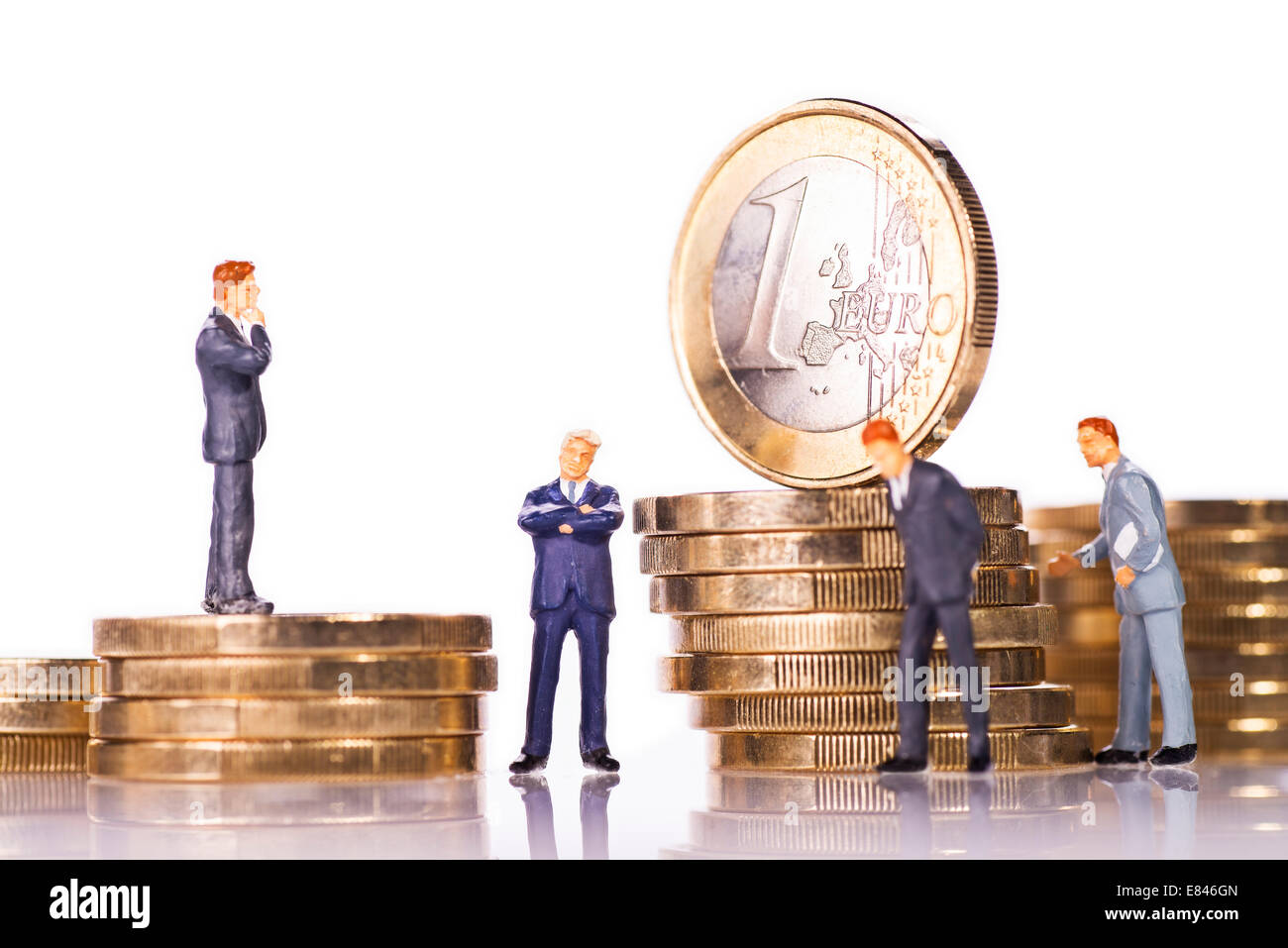 Model figures from business people with € coins Stock Photo - Alamy