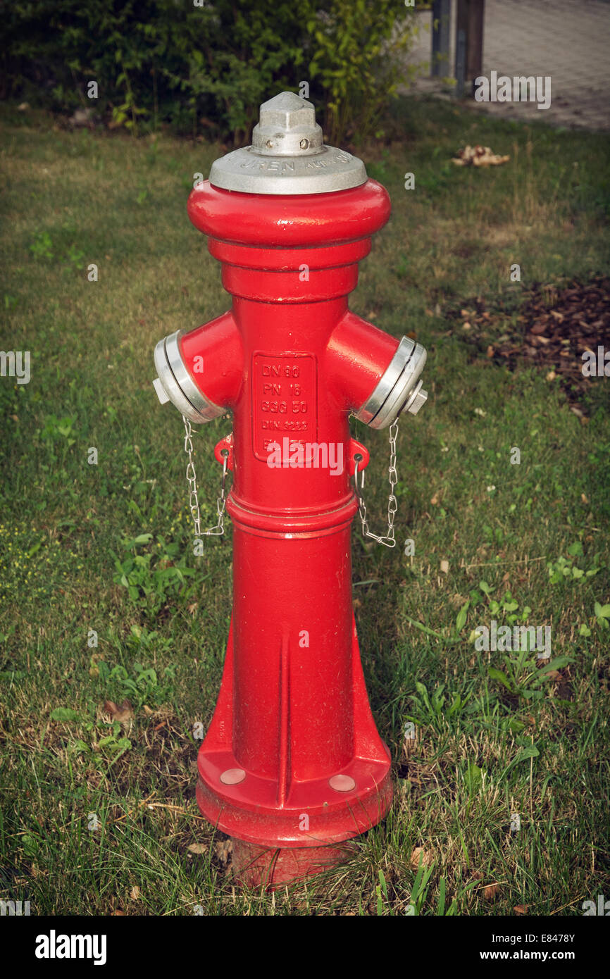 Red fire hydrant on a green lawn Stock Photo - Alamy