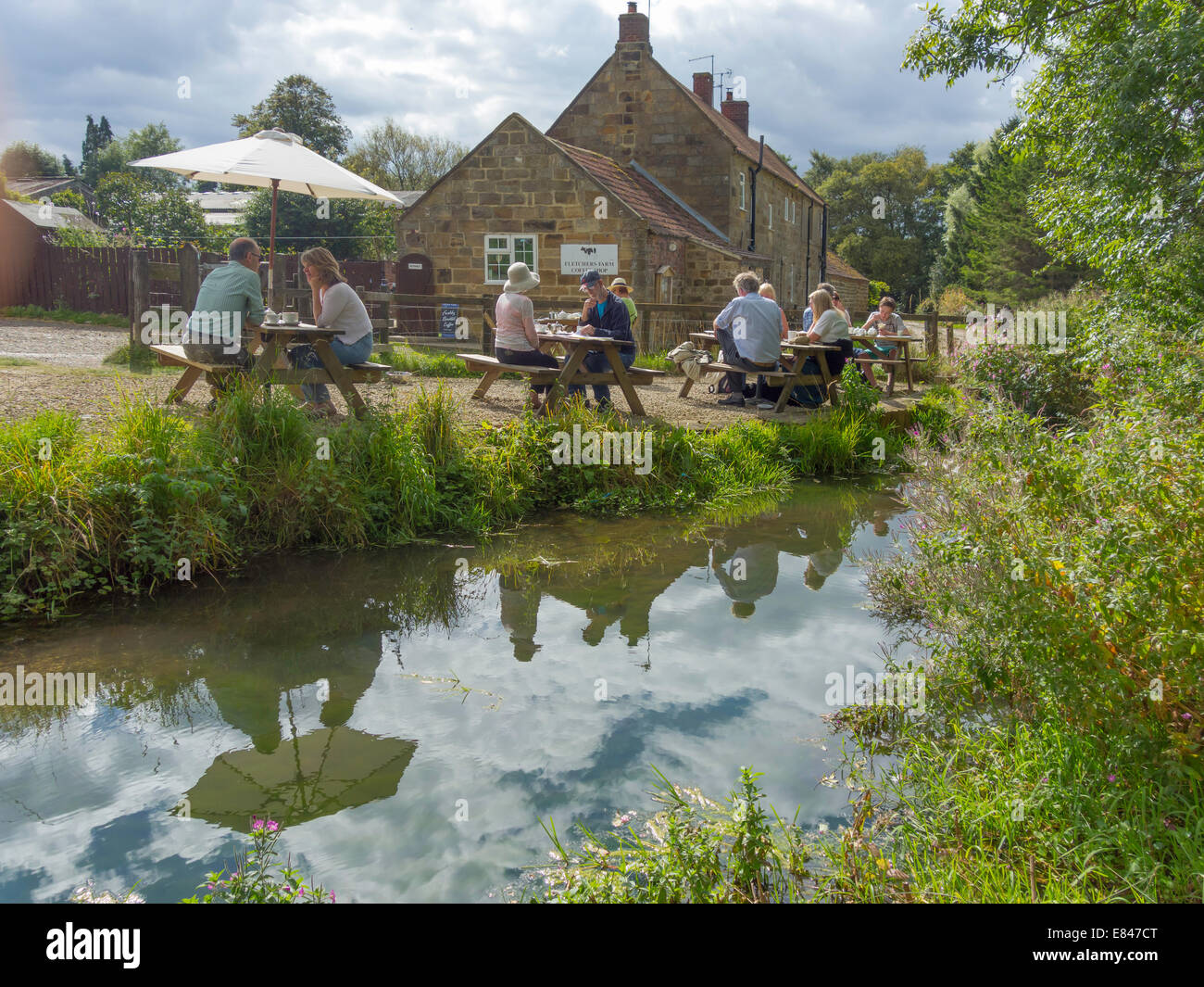 Couples enjoying afternoon tea in summer sunshine in a café at a farm ...