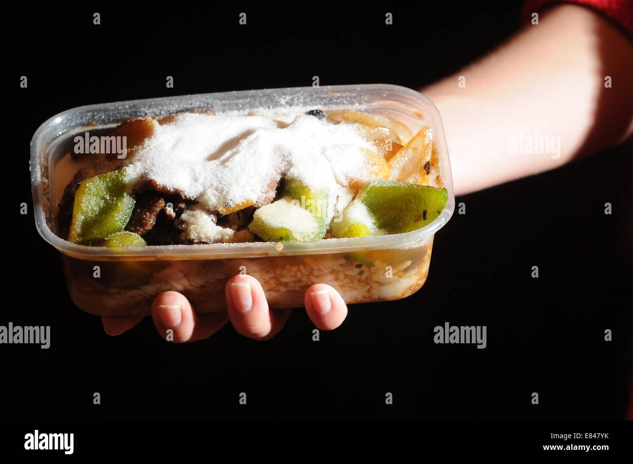 Takeaway food with salt being poured on from above. High levels of salt ...