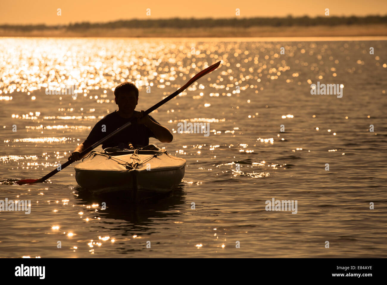 Silhouette of a man rowing in the canoe Stock Photo - Alamy