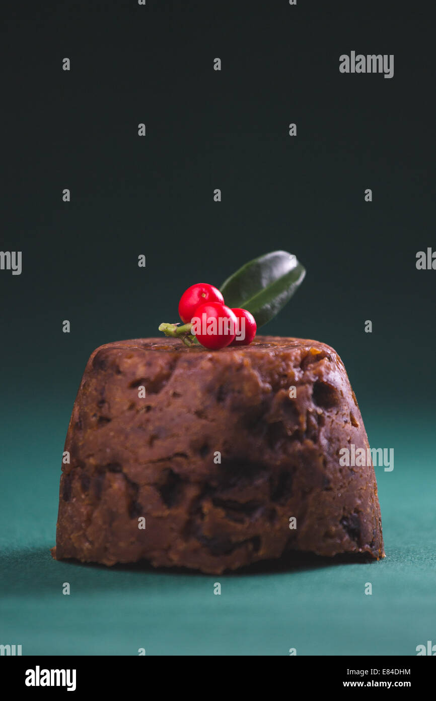Christmas pudding dressed with winter berries and leaves and dusted ...