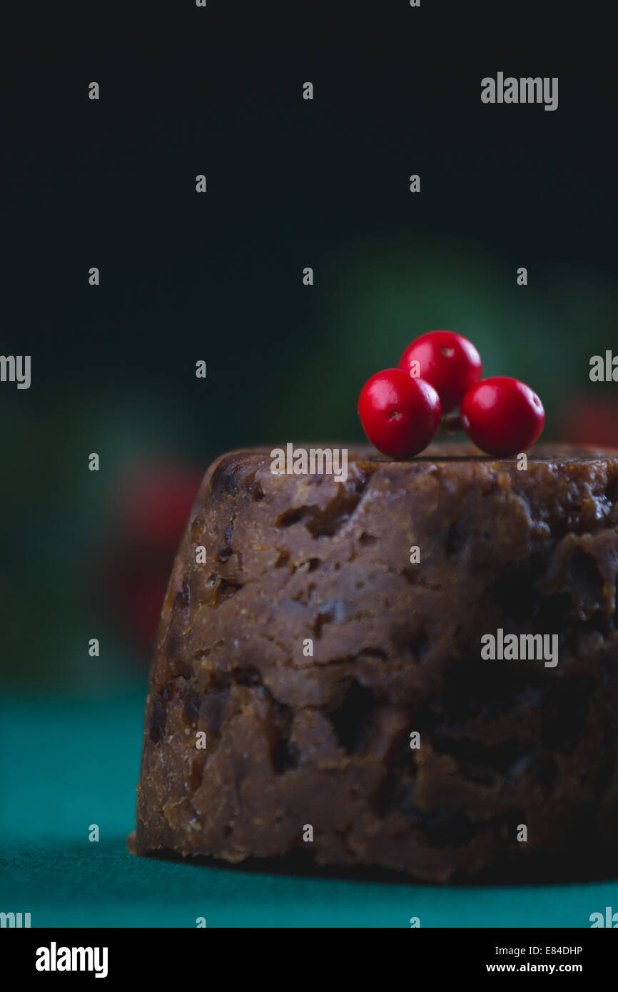 Christmas pudding dressed with winter berries and leaves and dusted ...