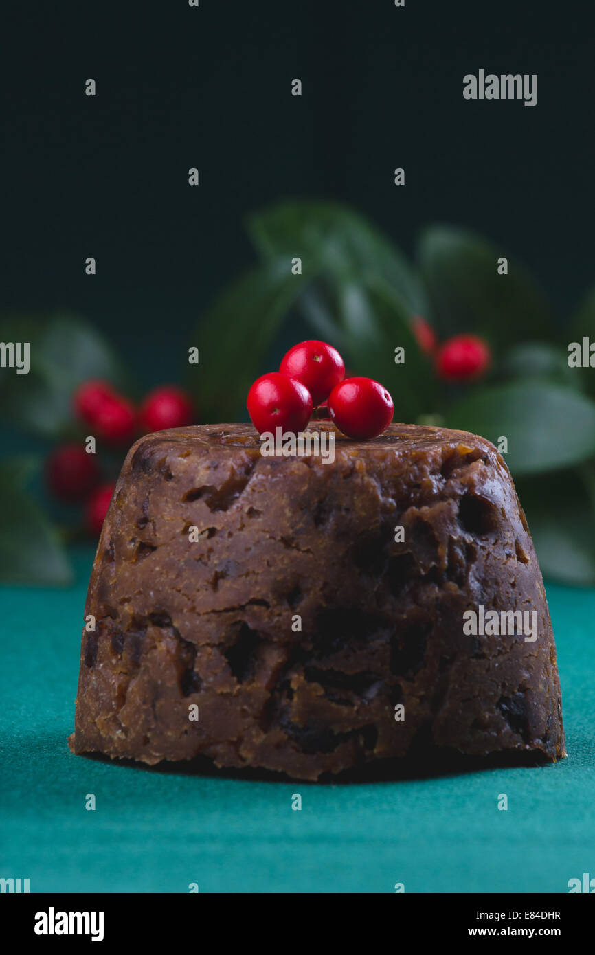 Christmas pudding dressed with winter berries and leaves and dusted ...