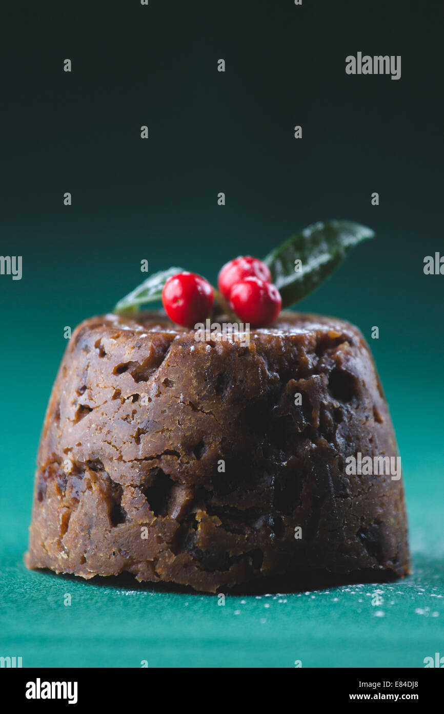 Christmas pudding dressed with winter berries and leaves and dusted ...