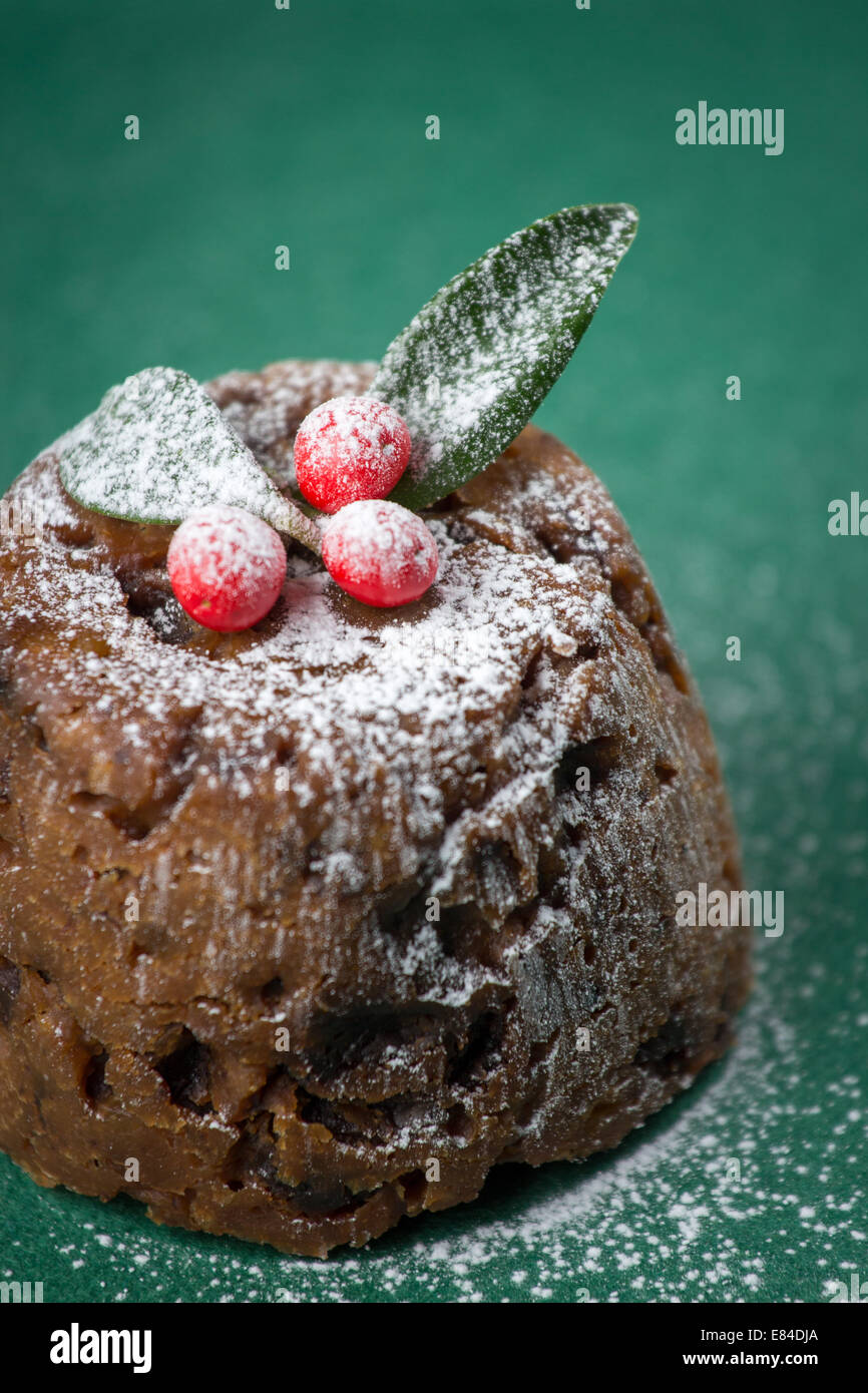 Christmas pudding dressed with winter berries and leaves and dusted ...