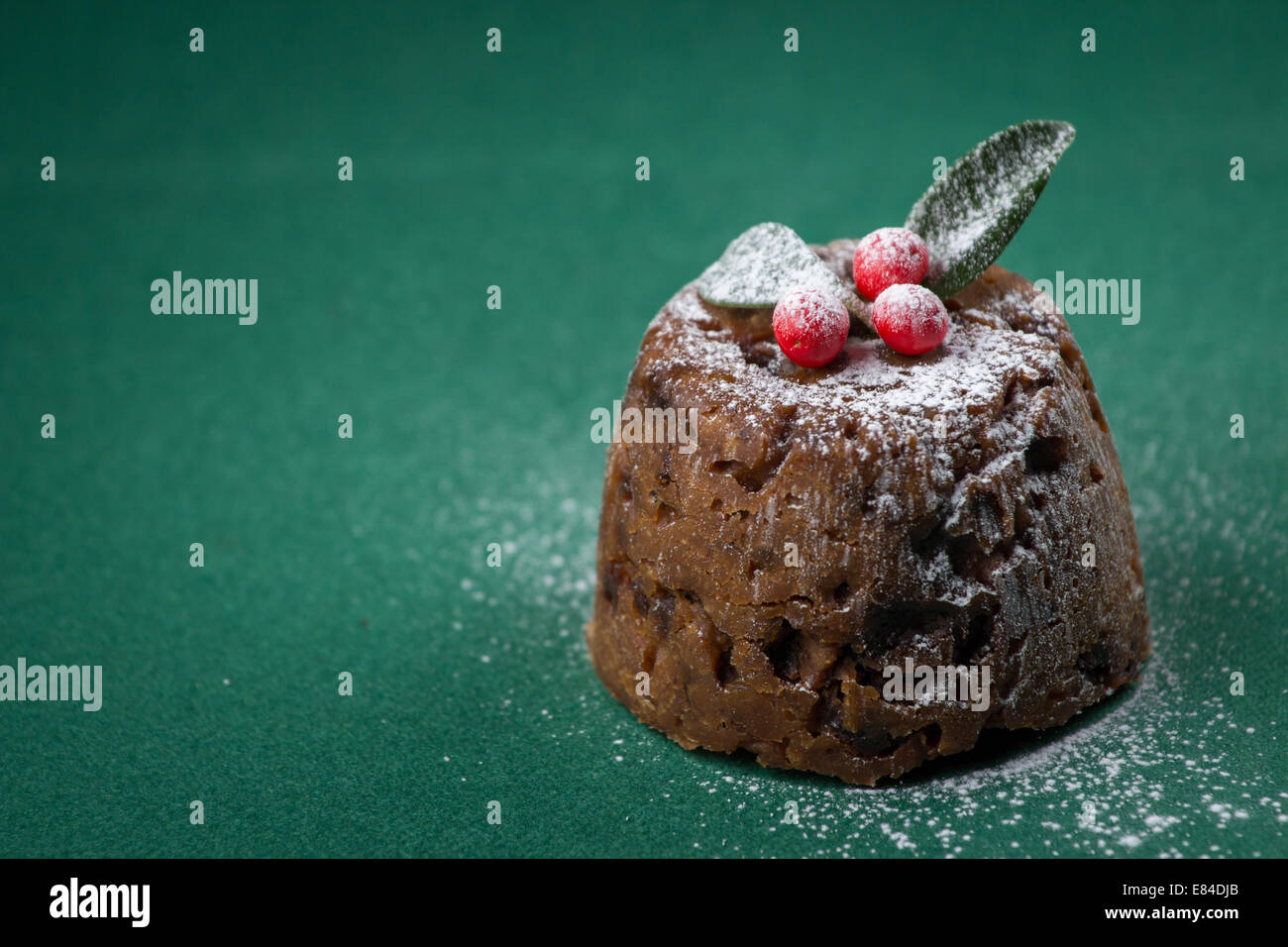 Christmas pudding dressed with winter berries and leaves and dusted ...