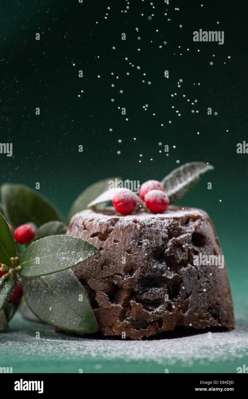Christmas pudding dressed with winter berries and leaves and dusted ...