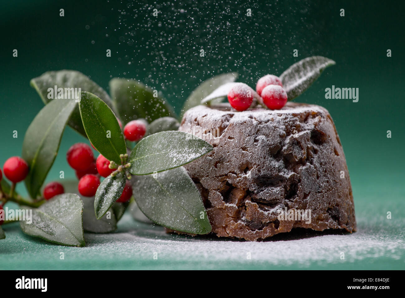 Christmas pudding dressed with winter berries and leaves and dusted ...