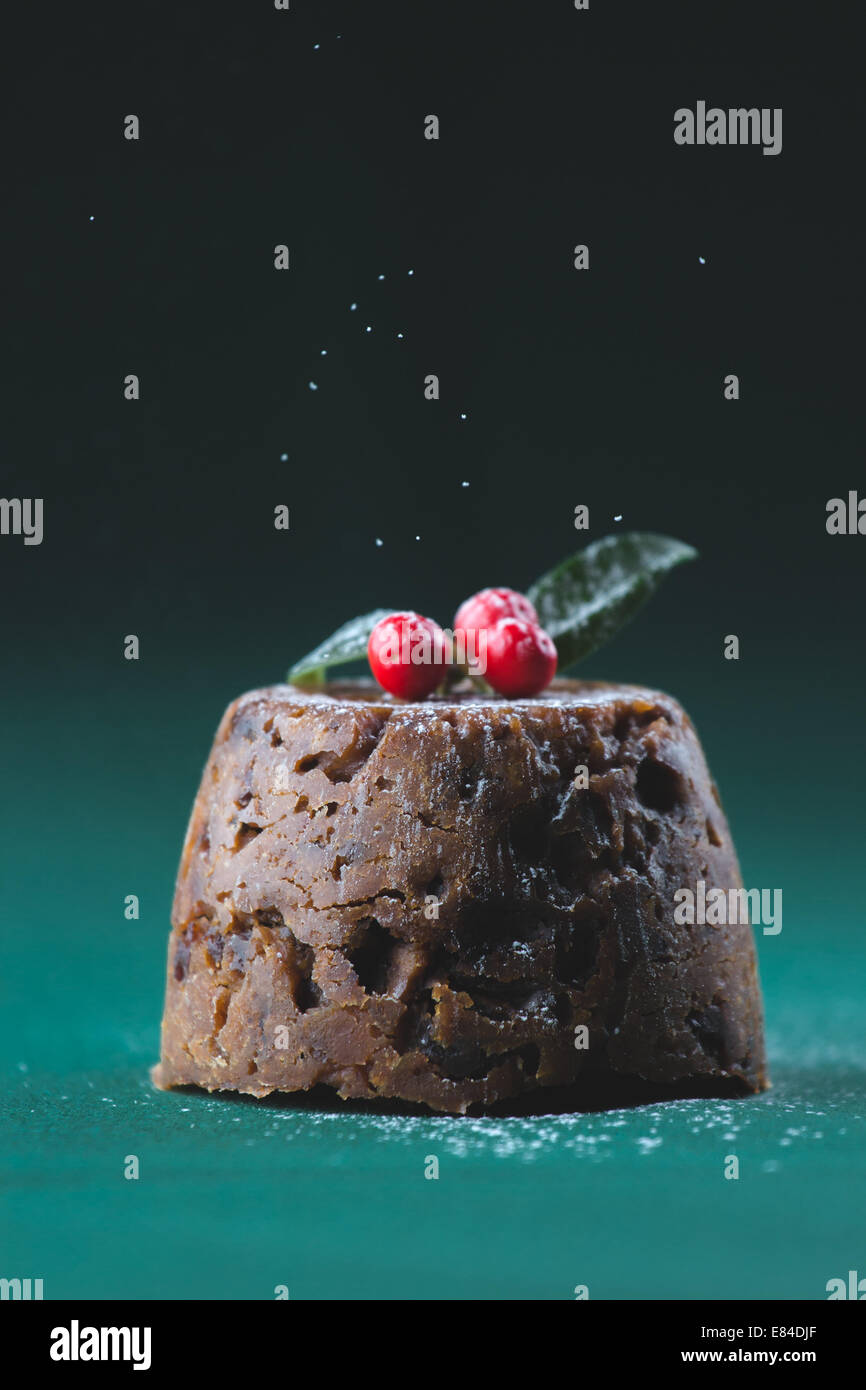 Christmas pudding dressed with winter berries and leaves and dusted ...