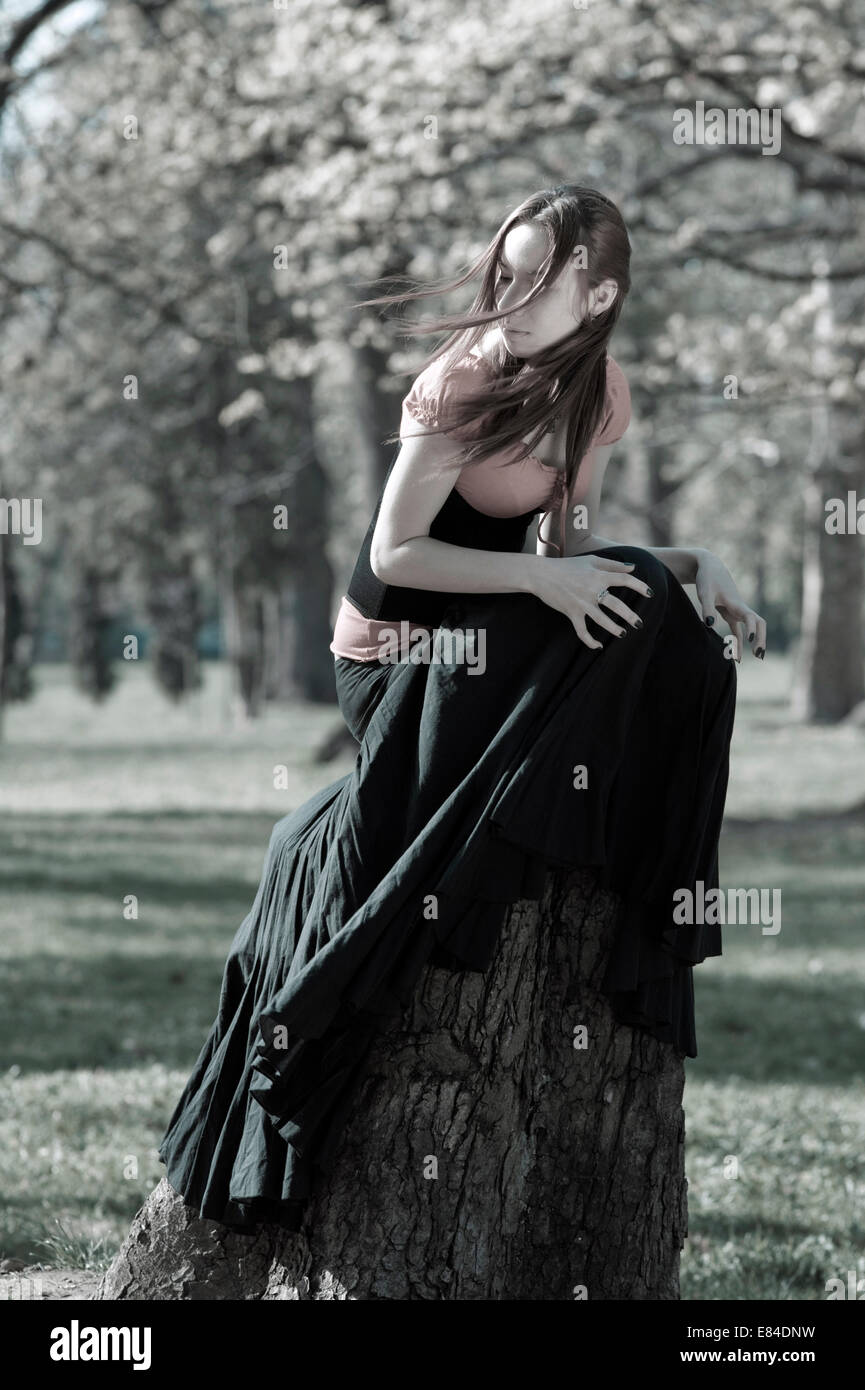 Portrait dark-haired woman sitting in tree Stock Photo - Alamy