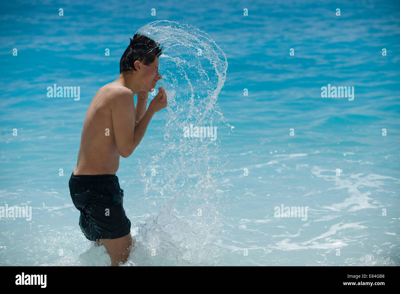 Boy throws back his wet hair Stock Photo - Alamy