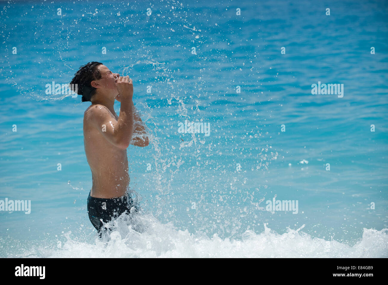 Boy throws back his wet hair Stock Photo - Alamy