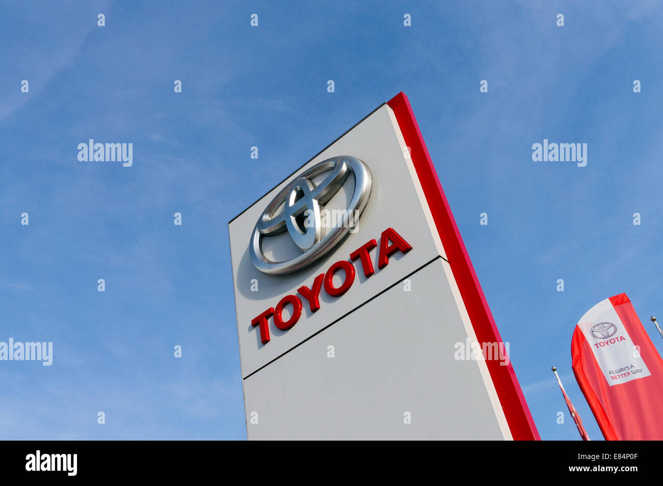 Looking up at Toyota car dealers sign with logo and blue sky and ...