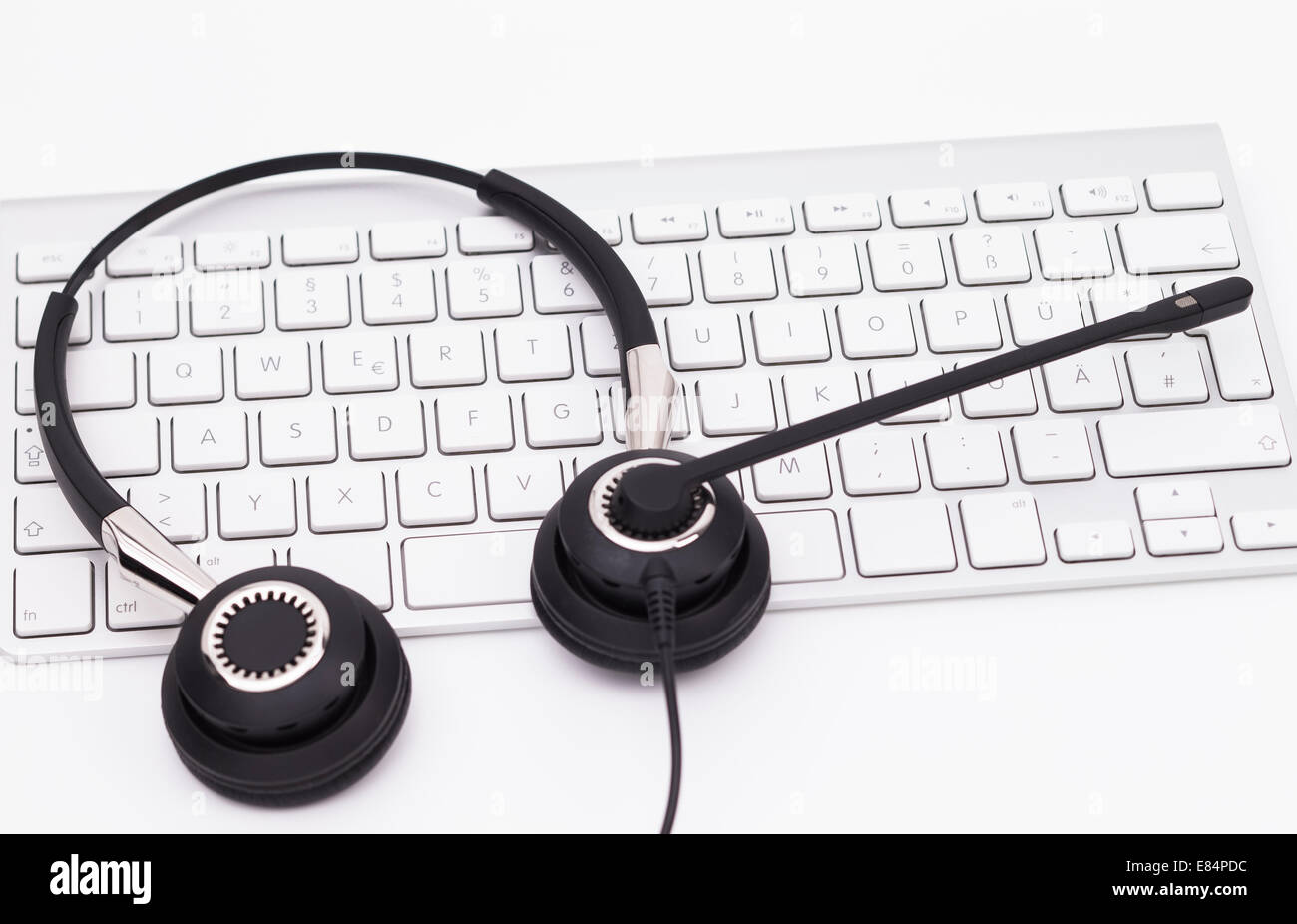 Office headphones with microphone over white keyboard on desk Stock ...