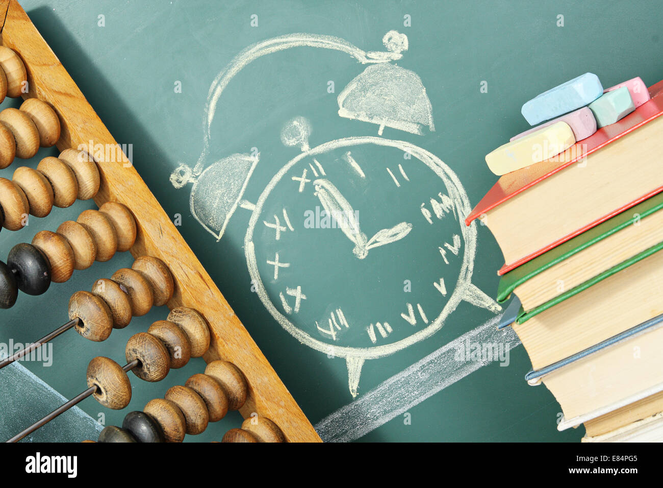 Books, abacus, chalk and chalk drawing of alarm clock. Education ...