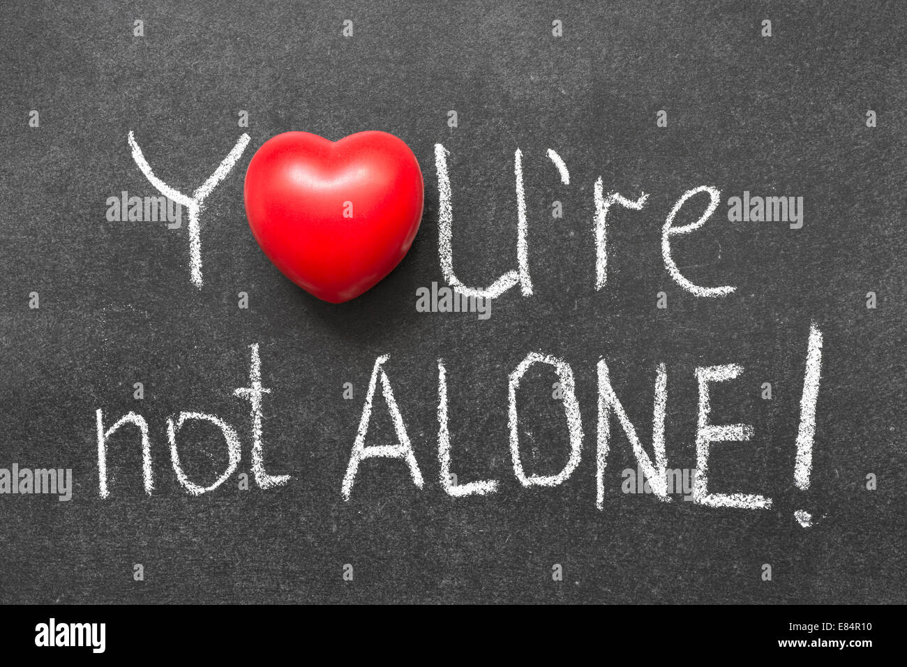 you're not alone exclamation handwritten on blackboard with heart ...
