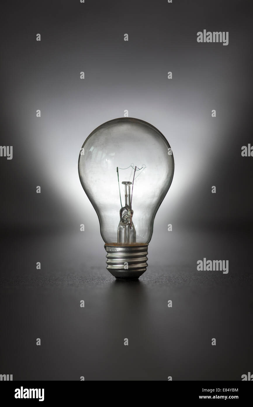 A clear light bulb, on a black background, lit from behind Stock Photo ...