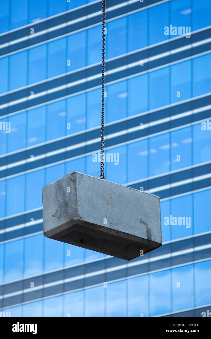 Cement block dangling from a chain during construction of a downtown ...