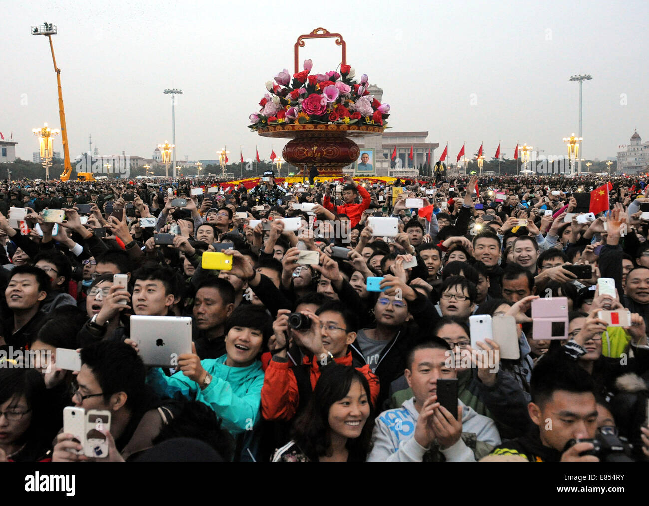Beijing, China. 1st Oct, 2014. People take photos of the flag-raising ...