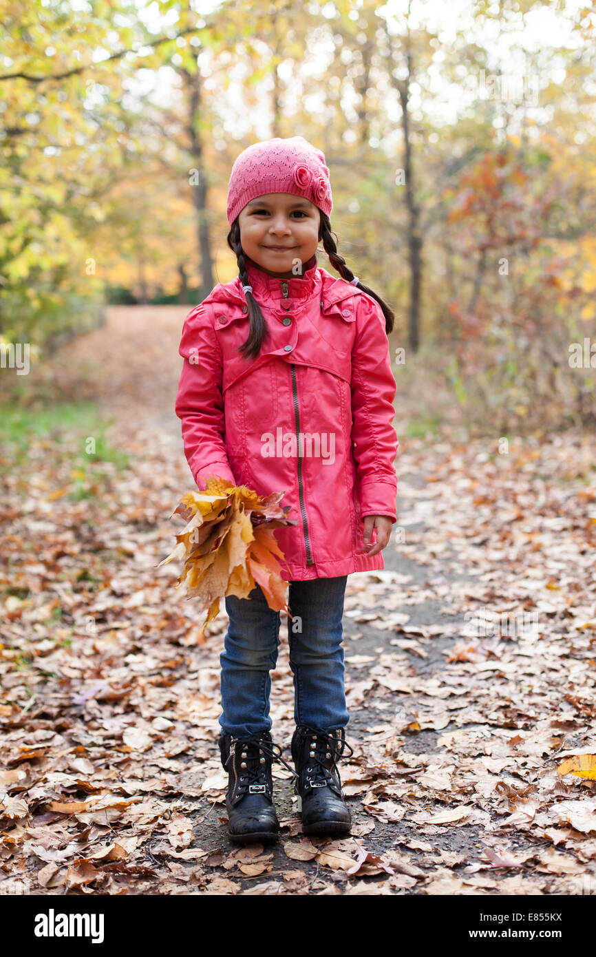 Little girl with autumn leaves in an autumn park Stock Photo - Alamy