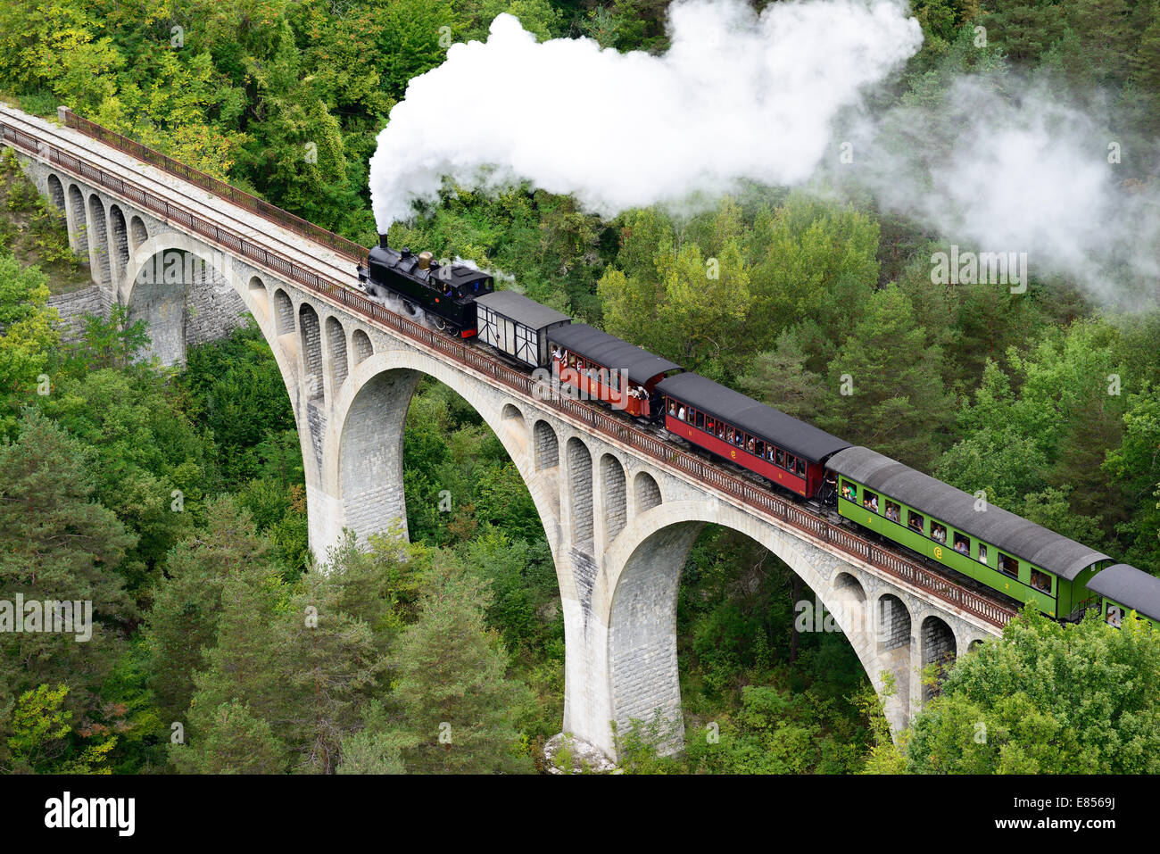 AERIAL VIEW. Historic and touristic steam train on a viaduct. Train des ...