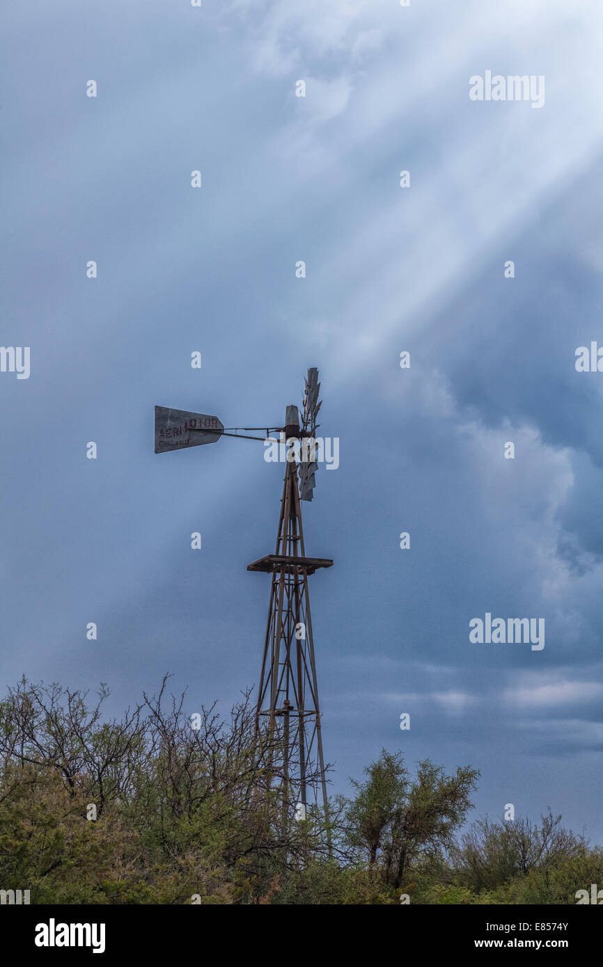 Windmill with storm clouds and sun rays in Big Bend National Park in ...