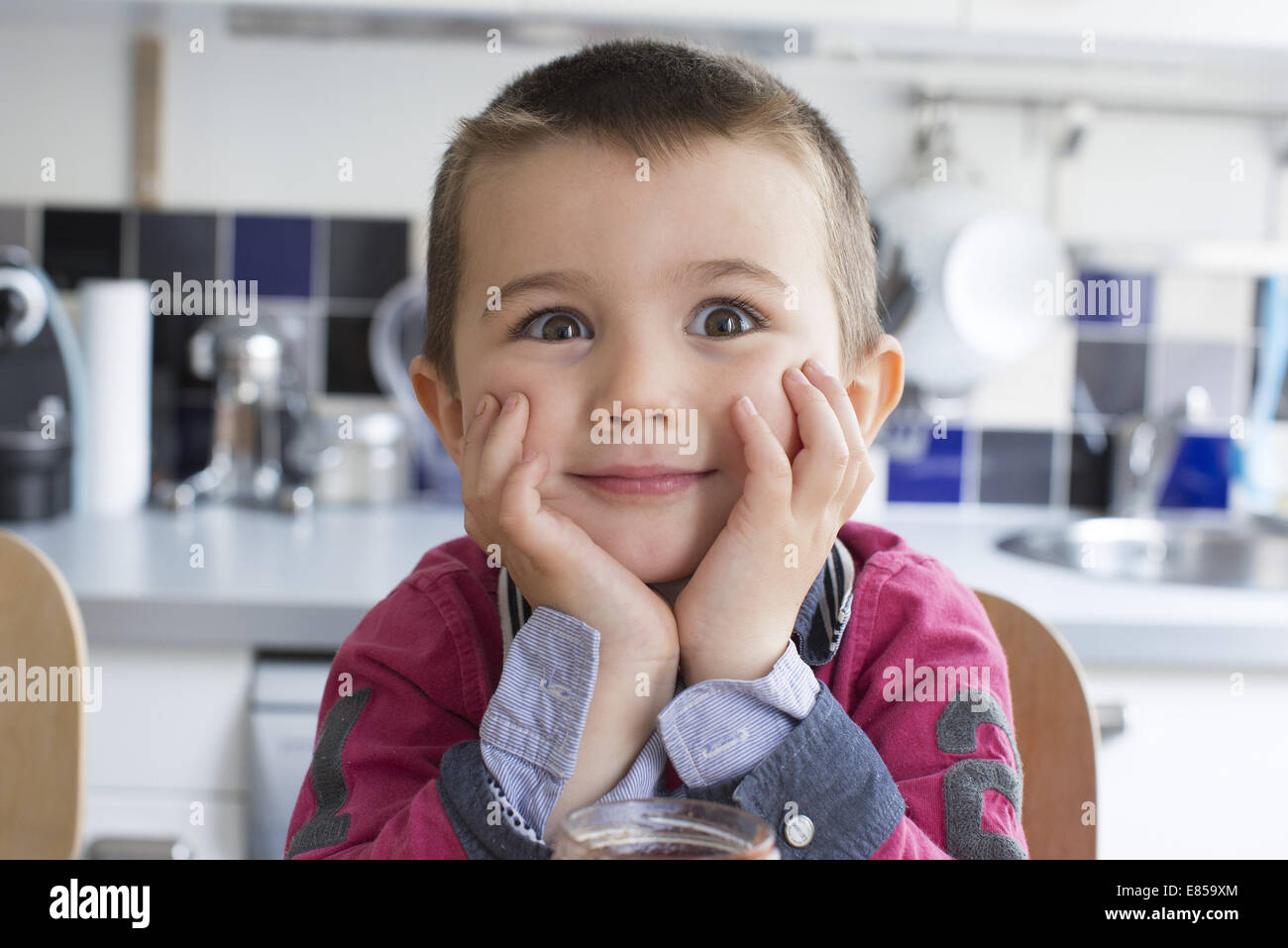 Little boy with chin resting on hands, looking surprised Stock Photo ...
