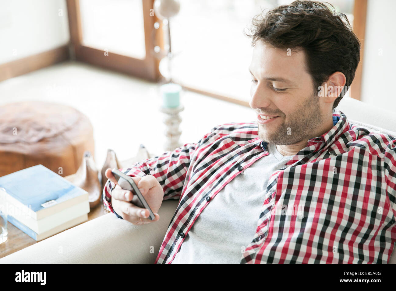 Man using smartphone at home Stock Photo - Alamy