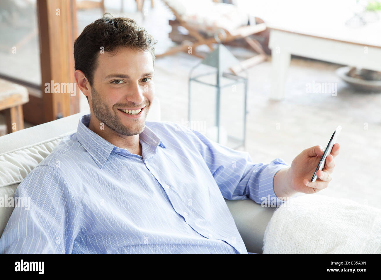 Man using smartphone, smiling Stock Photo - Alamy