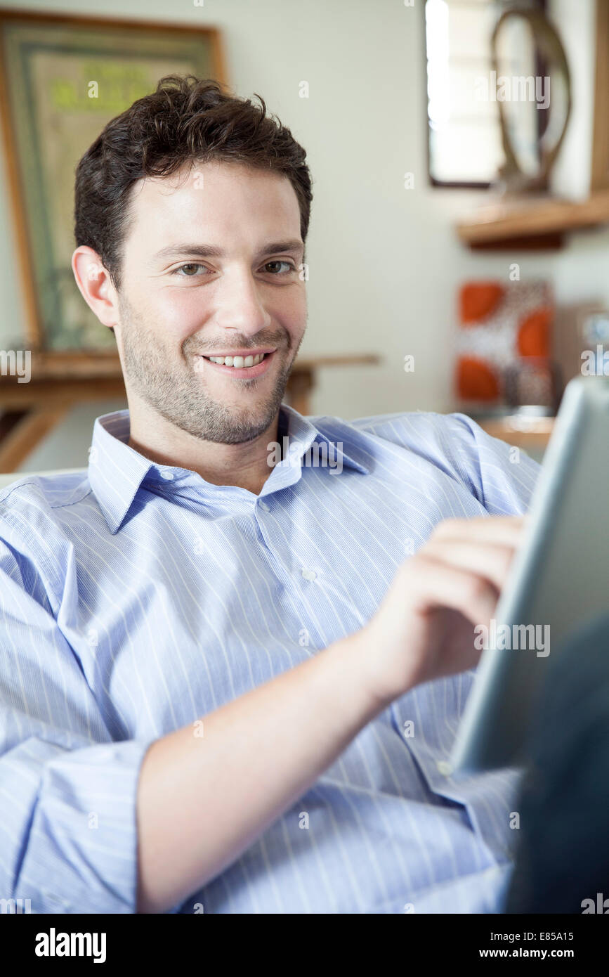 Man using digital tablet, smiling at camera Stock Photo - Alamy