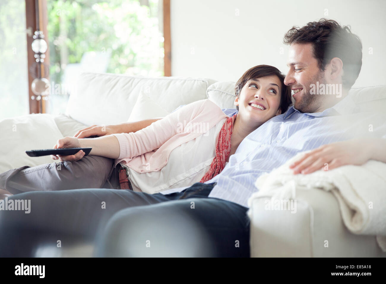 Couple watching TV together on sofa Stock Photo - Alamy