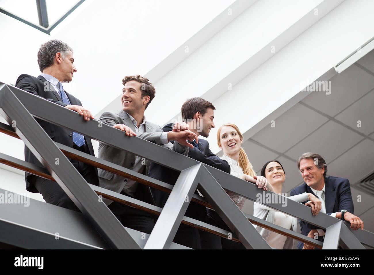 Team of executives talking together on balcony Stock Photo - Alamy