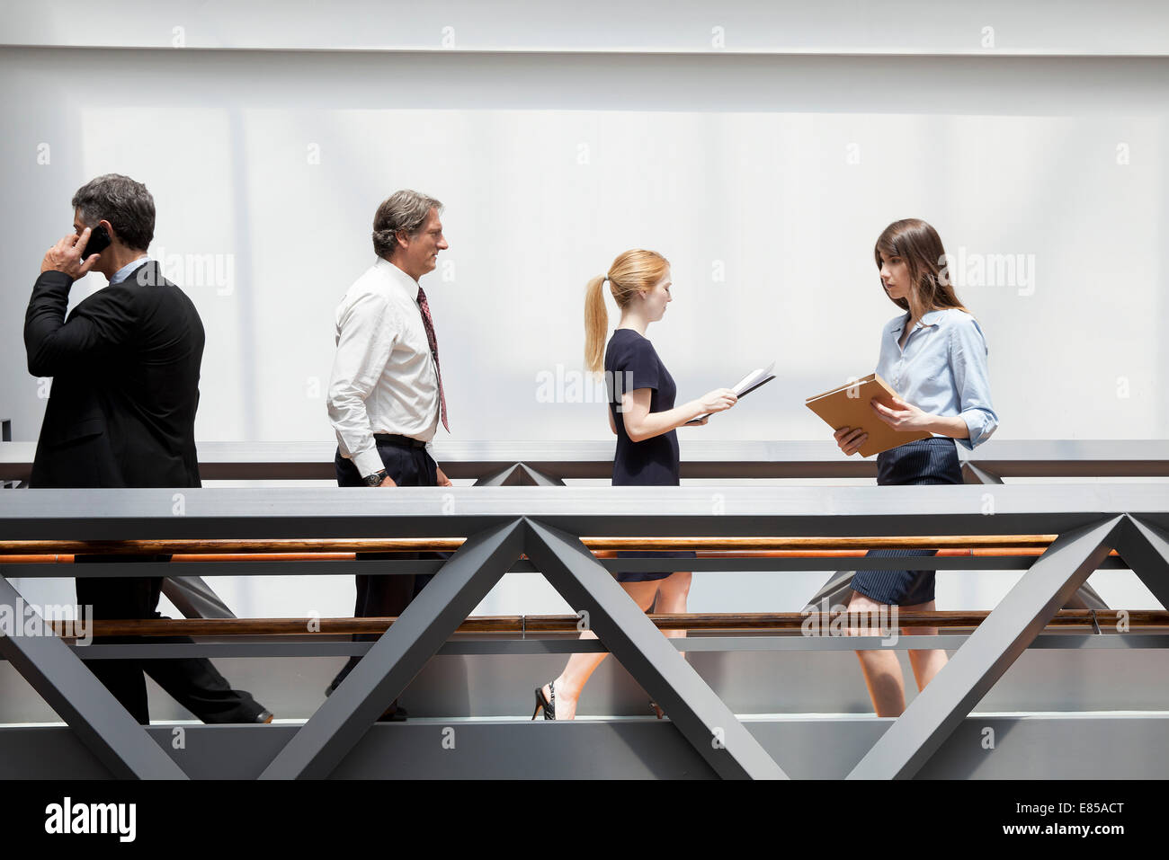 Business professionals walking through corridor Stock Photo - Alamy