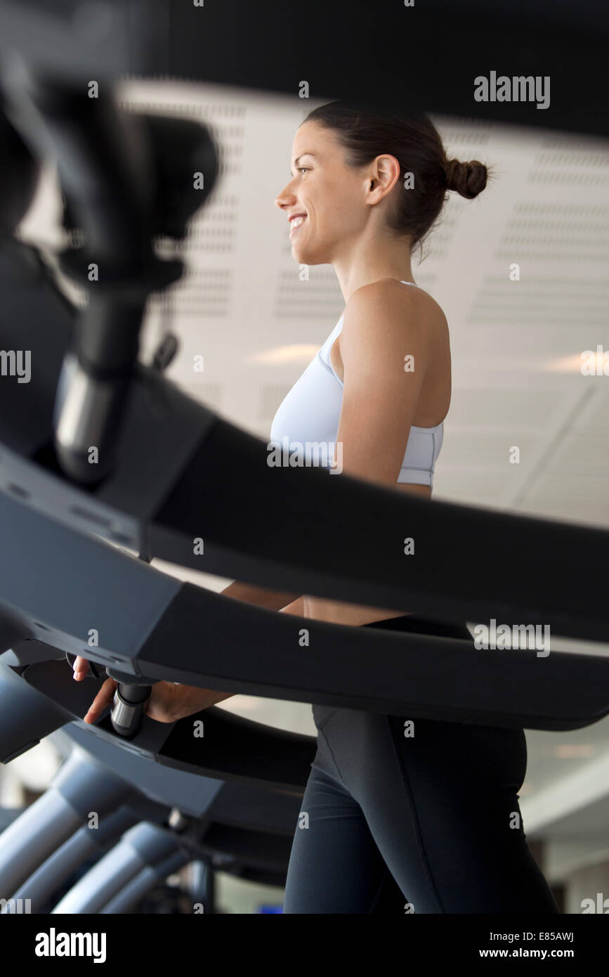 Woman on exercise machine at gym Stock Photo - Alamy