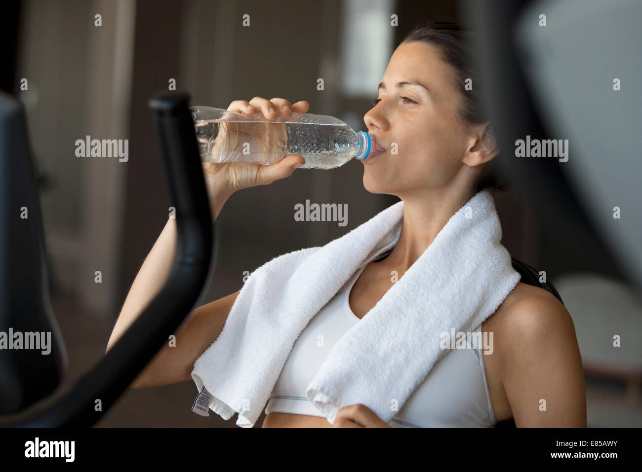 Woman drinking water in health club Stock Photo - Alamy