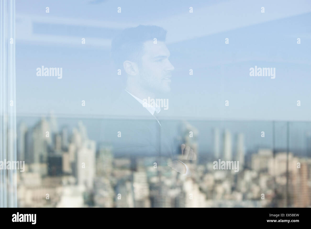 Businessman looking through window Stock Photo - Alamy